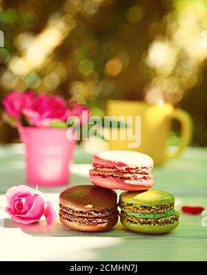 French colored macaroons with white cup of coffee Stock Photo - Alamy