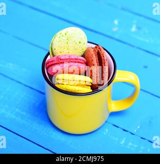 Pink macarons in a ceramic cup on a black background.Low key.Sweets and ...