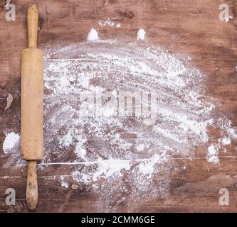 White flour scattered on rustic wooden table with baking background and ...