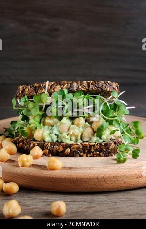 Sandwich of rye bread with cereals with crushed avocado, chickpeas and ...