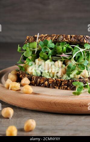 Sandwich of rye bread with cereals with crushed avocado, chickpeas and ...
