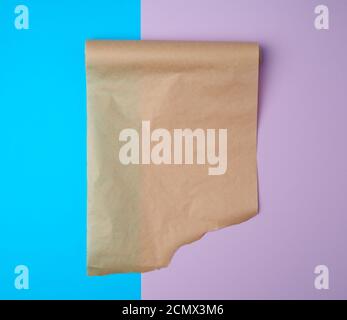 unwrapped a roll of brown parchment paper on a colored background ...