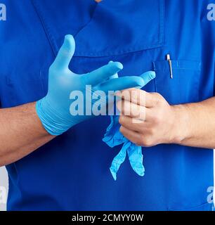 doctor in blue uniform and latex gloves is holding an empty plastic ...