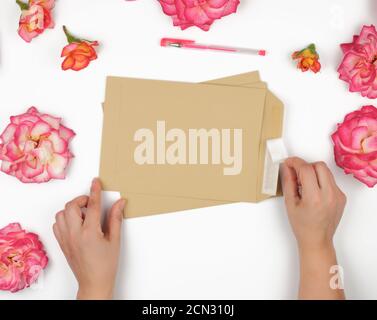 Two hands hold a fresh red tomato and a yellow bell pepper. The setting ...