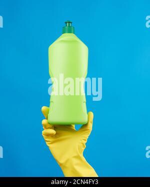 A human hand holds a green and yellow health insurance card. A ...