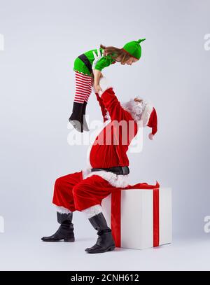 Jolly elf and Santa Claus play together Stock Photo - Alamy