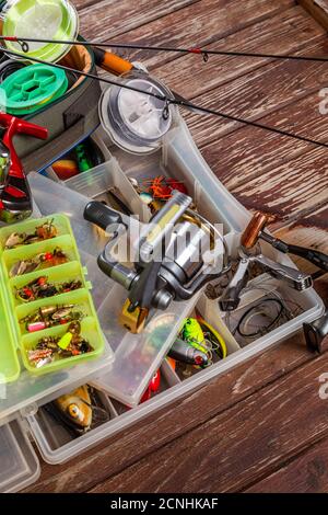 Different fishing tacles with rod and reels on wooden brown background ...