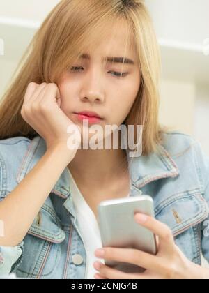 Unhappy businesswoman looks at smart phone while feeling upset about ...