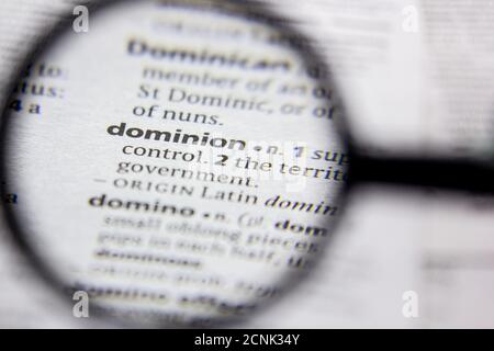 The definition of the word Dominion in a dictionary, under magnifying ...