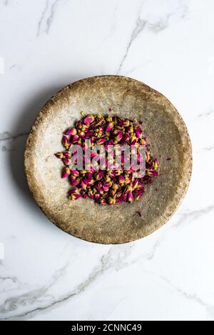 Dried tea rose, dessert rose-buds in a ceramic cup. Selective focus ...
