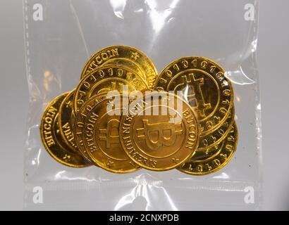 golden bitcoin coins in a plastic back, representing the electronic ...