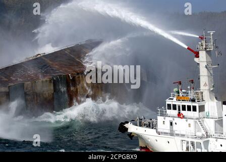 Fire fighting boat sprays water in port Stock Photo - Alamy