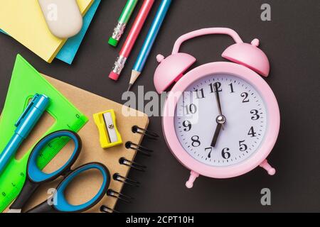 School supplies on a black chalkboard background. Composition with ...
