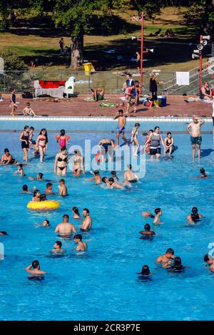 Crowded outdoor swimming pool full of people bathing in Germany, on a ...