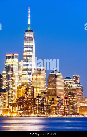 The Freedom Tower, Wall Street, and the skyline of downtown Manhattan from Brooklyn at sunset ...