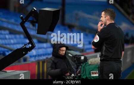Referee Michael Oliver views the pitch-side VAR screen and then sends ...