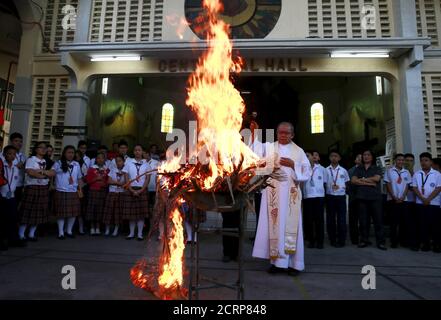 A Catholic priest sprinkles ash on the head of a devotee during Ash ...
