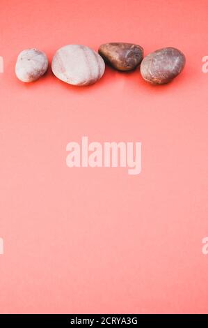 Vertical shot of pebbles isolated on a pink background Stock Photo - Alamy