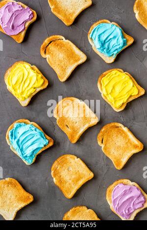 Pattern of toast bread with colored cheese spread. Layout top view ...