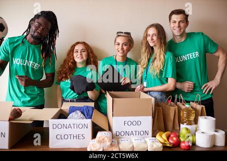young enthusiastic volunteers with donations for poor people, cardboard ...