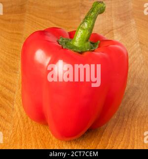 One red sweet pepper on a wooden board Stock Photo - Alamy