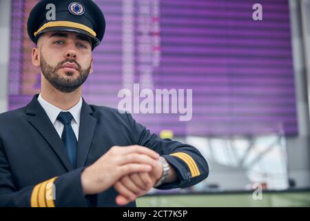 Handsome male pilot standing in airport terminal Stock Photo - Alamy