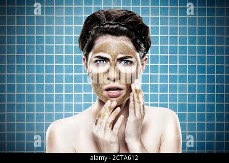 amazed young woman applying face cream on blue background Stock Photo ...