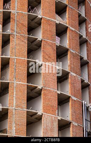 Unfinished concrete and red brick building project under construction ...