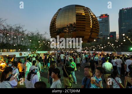 People walk around and shop at the "2020 Amazing Night in Hangzhou", a ...