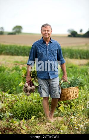 Farmer collecting vegetables in the field Stock Photo - Alamy
