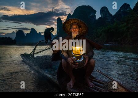 In this undated photo, an old fisherman drives his raft, fishing with ...