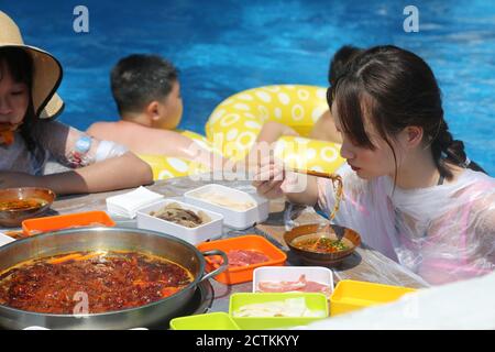 Tourists eat hotpot while sitting in a ice bucket to enjoy spicy ...