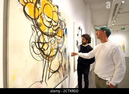 George Morton-Clark discusses one of his works with a visitor during ...