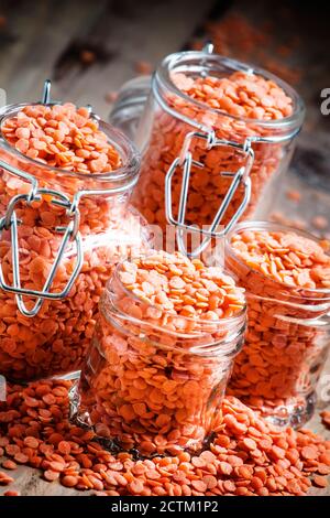 Useful red lentils in glass jars for storage on old wooden background ...