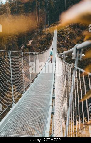 Person on a self-anchored suspension bridge Stock Photo - Alamy