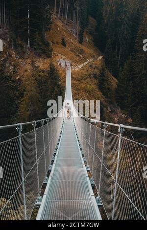 Person on a self-anchored suspension bridge Stock Photo - Alamy