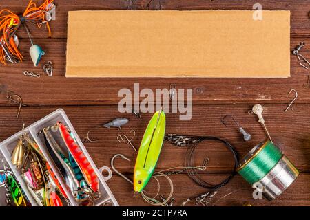 Different fishing tacles with lures and reels on wooden brown ...