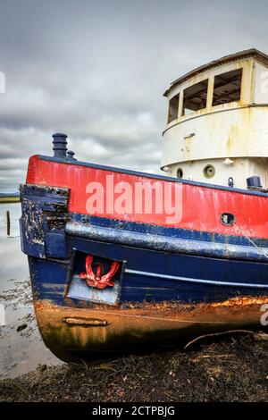 A rusty abandoned fishing vessel beached off the causeway to Roa Island ...