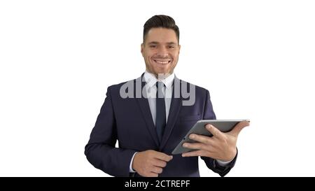 Handsome man swiping pages on tablet and smiling to camera on gradient ...
