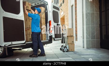 delivery man uses trolley full of cardboard boxes Stock Photo - Alamy