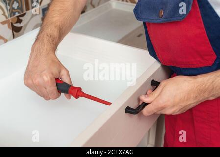 Young service contractor assembling kitchen furniture Stock Photo - Alamy