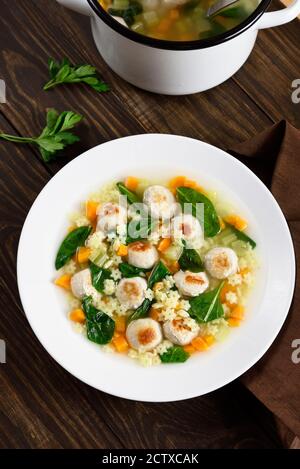 Delicious small meatballs with spinach in a creamy sauce in the frying ...