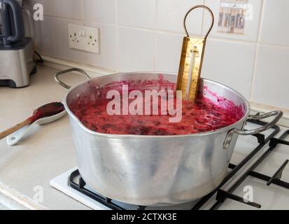 Jam making - a traditional brass thermometer in a preserving pan of ...