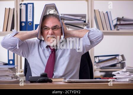 Old employee unhappy with excessive work Stock Photo - Alamy
