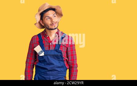 Young handsome man weaing handyman uniform looking away to side with ...