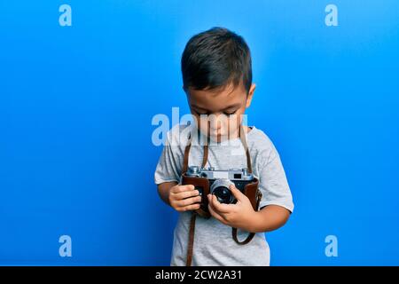 Adorable latin photographer toddler smiling happy using vintage camera ...
