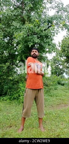 Serene Indian guy practicing yoga outdoors. Young yoga practitioner ...