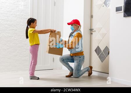 masked delivery woman delivers food during virus outbreak, coronavirus ...