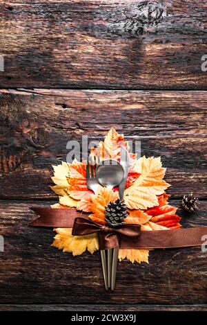 Autumn thanksgiving table with tableware and red tissue over wooden ...