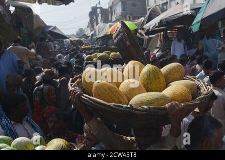 Pakistani farmers busy in their trucks loaded with watermelon at a ...